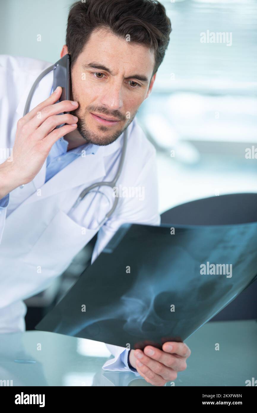 doctor radiologist on the phone looking at x-ray scan Stock Photo - Alamy