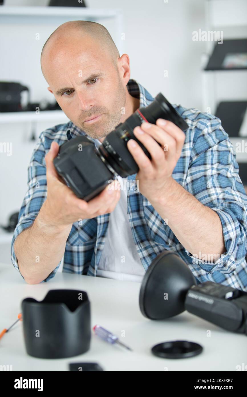 male repairing an camera at his workplace Stock Photo - Alamy