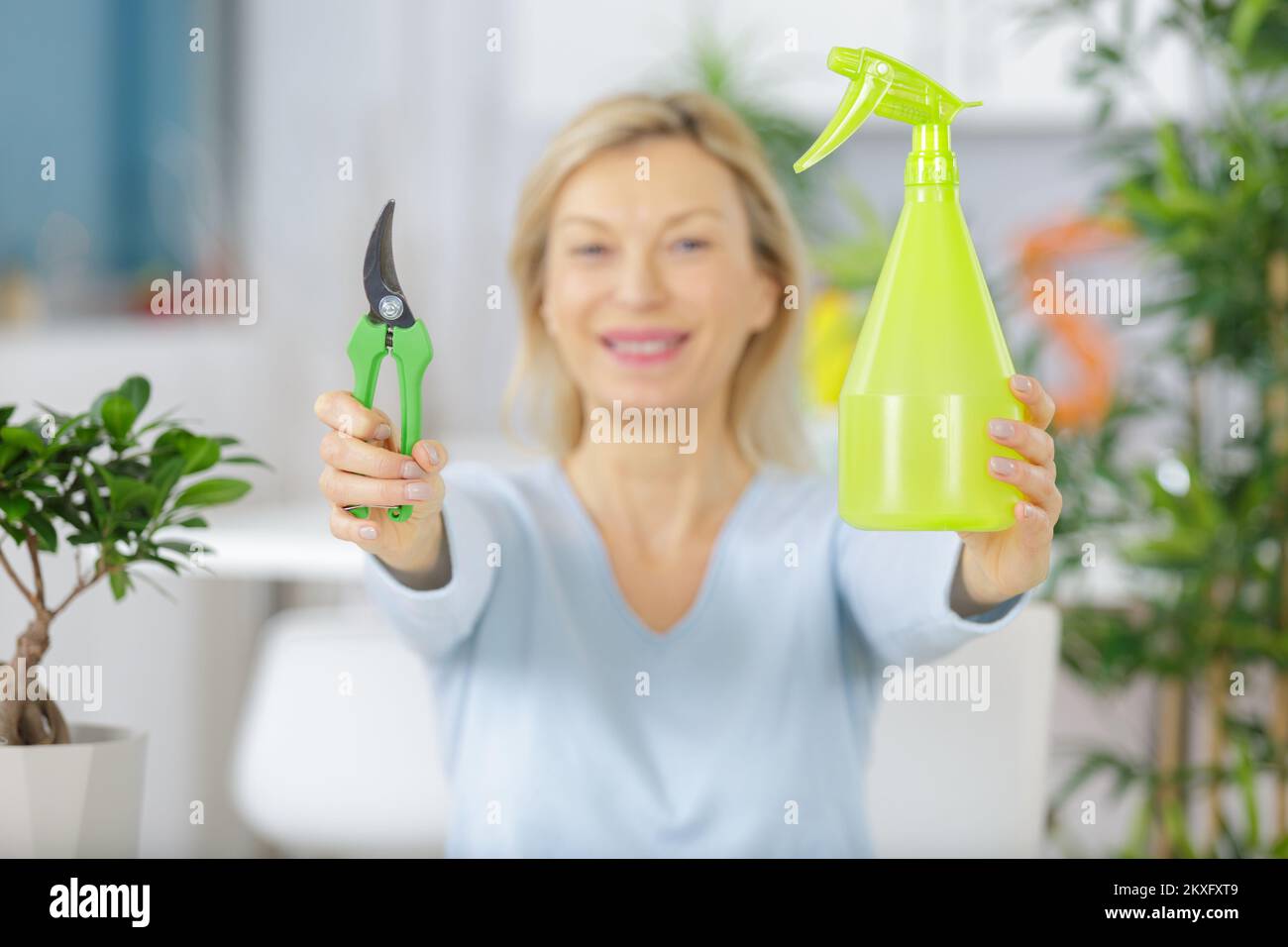 female gardener showing water spray and scissors Stock Photo - Alamy