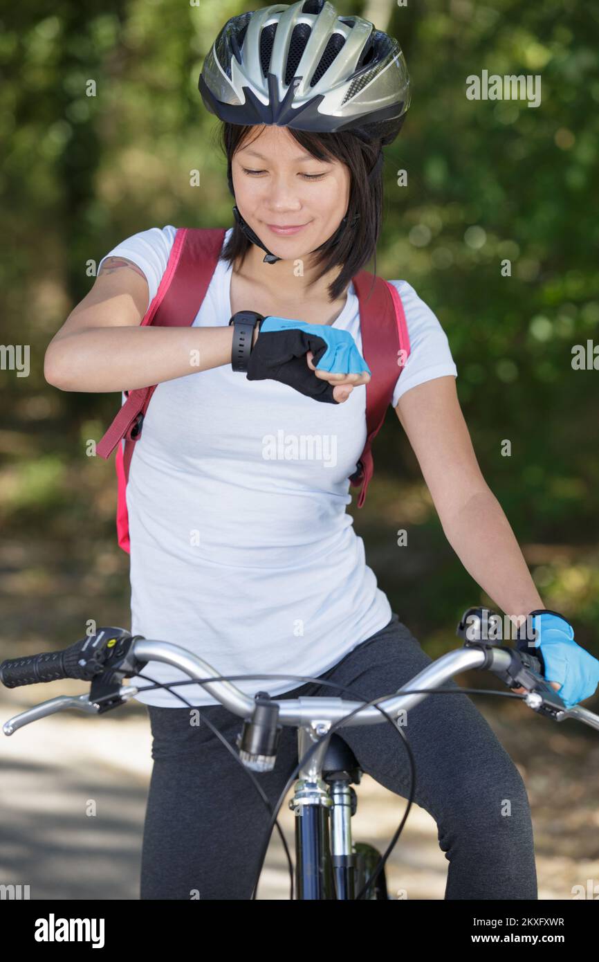 female cyclist checking progress on smart watch Stock Photo - Alamy