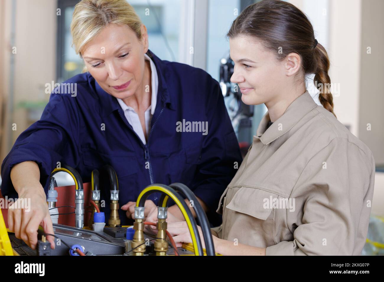 two women in uniforms and job in factory Stock Photo - Alamy