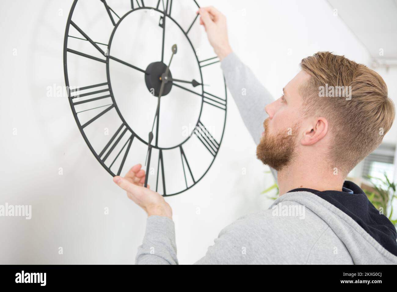 man putting a clock on the wall Stock Photo - Alamy