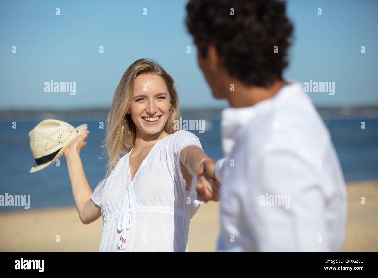 happy couple dancing with hands held together on the beach Stock Photo ...