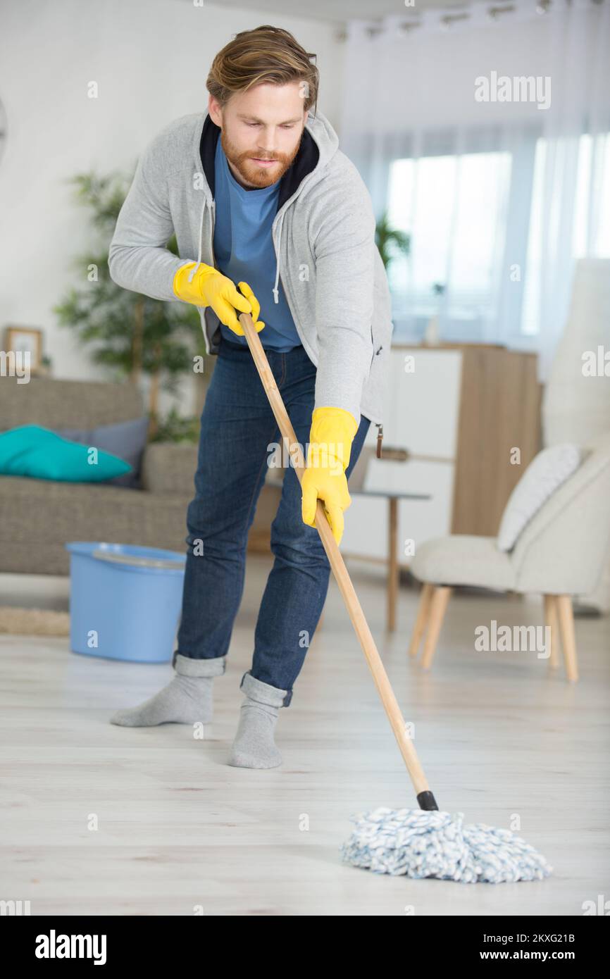 young man cleaning mopping the floor Stock Photo - Alamy