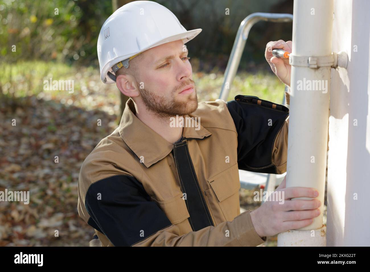 construction worker checking outdoors pipe Stock Photo - Alamy