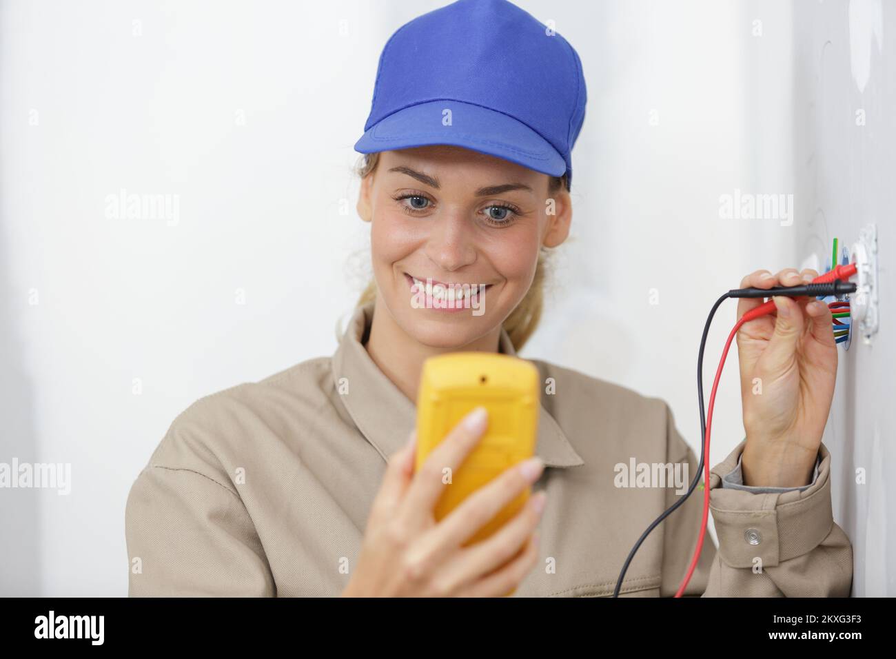 happy female electrician testing a wall socket Stock Photo - Alamy