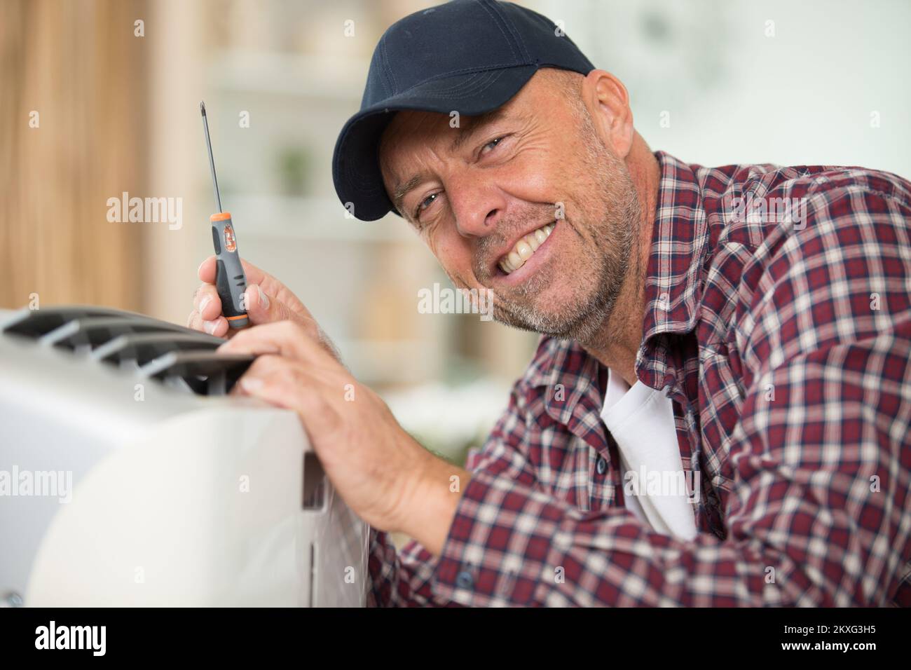 senior handyman using screwdriver on electrical appliance Stock Photo ...