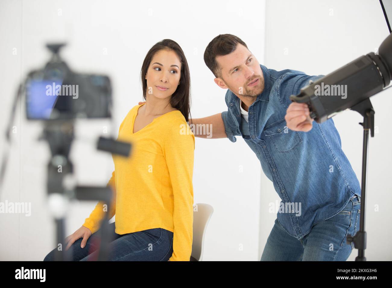 young female model being photographed in studio by photographer Stock ...