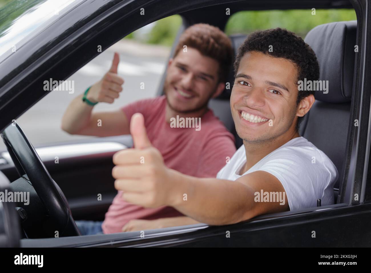 happy men inside car showing thumbs up Stock Photo - Alamy