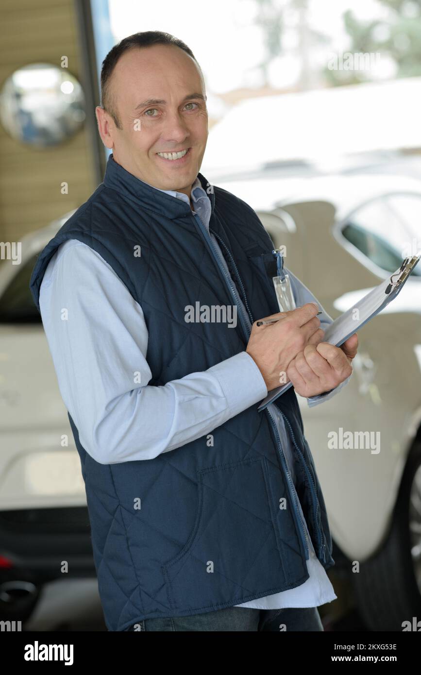 portrait of vehicle inspector holiding clipboard Stock Photo - Alamy