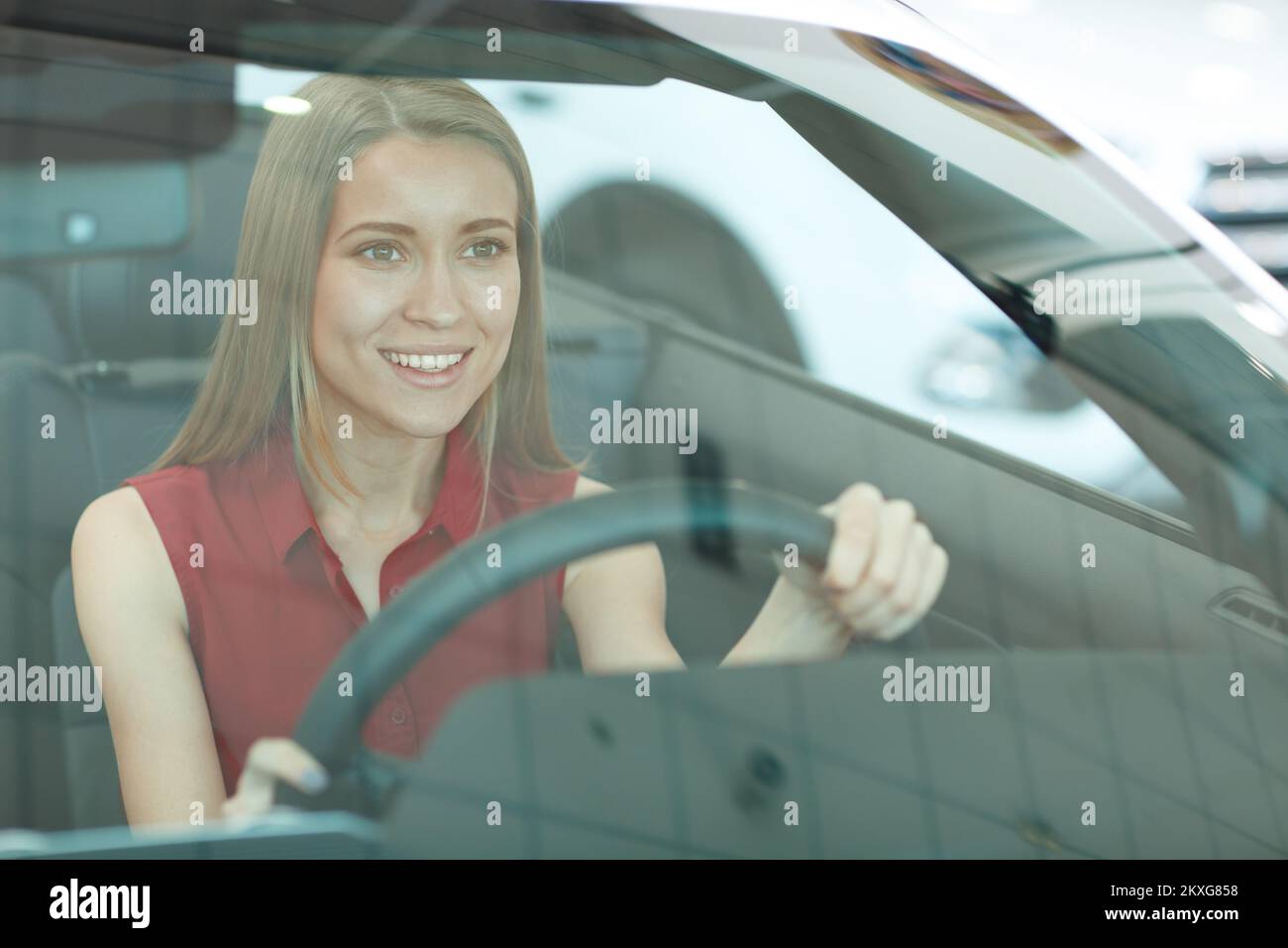 Female customer behind windscreen testing car in car saloon Stock Photo ...