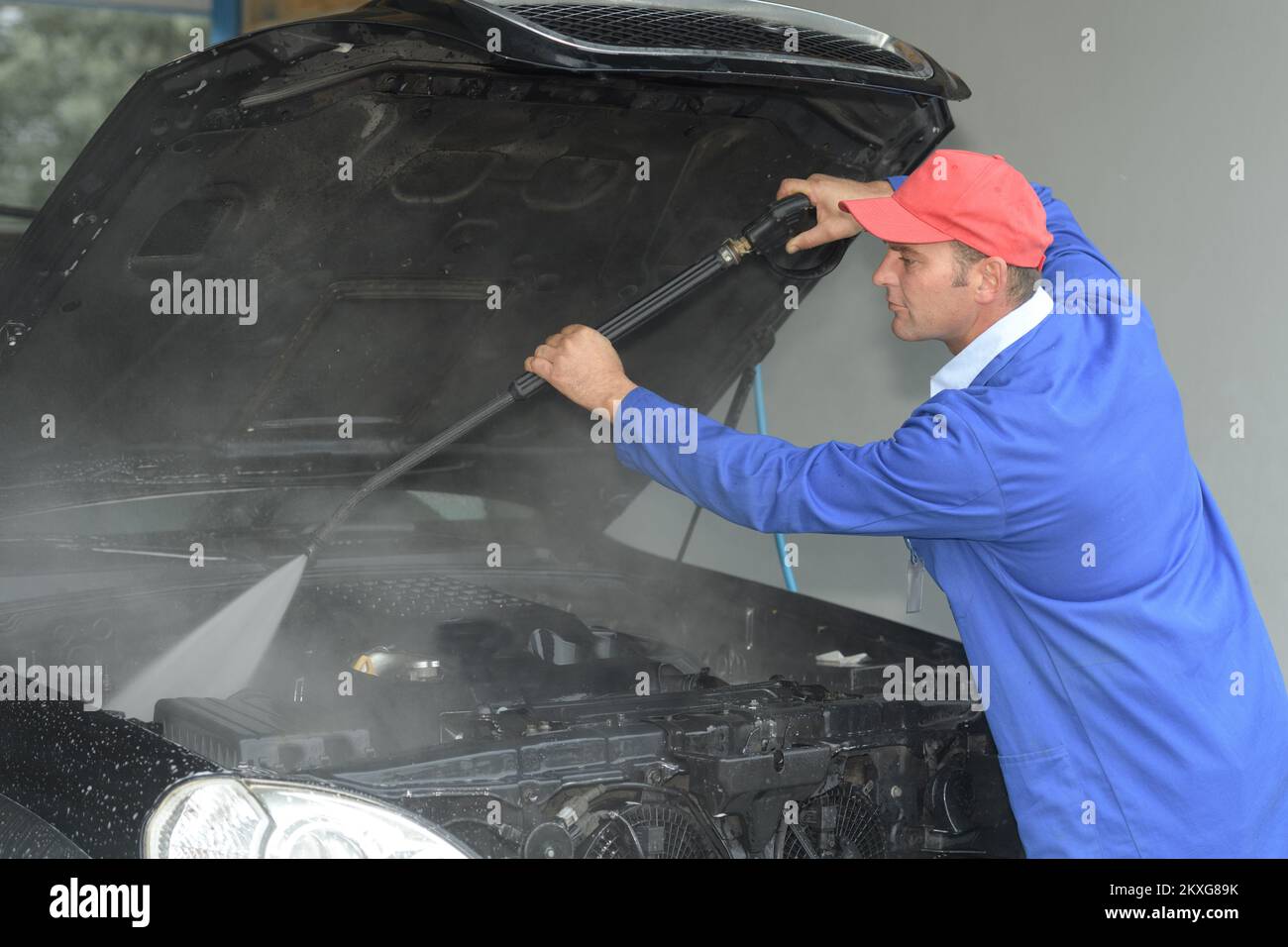 man power washing automobile engine bay Stock Photo - Alamy