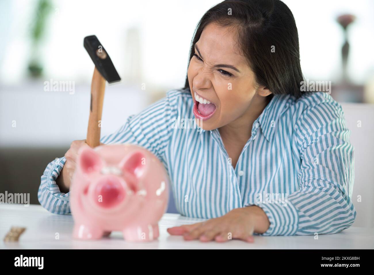 angry woman breaking piggy bank Stock Photo - Alamy