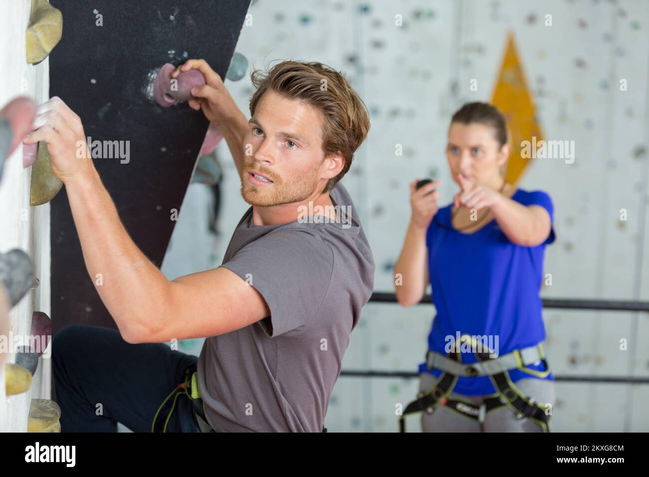 man climbing indoor wall against the clock Stock Photo - Alamy