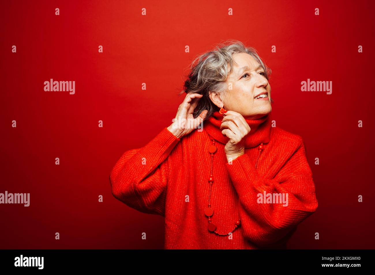 Senior woman wearing red clothes over a red background Stock Photo - Alamy