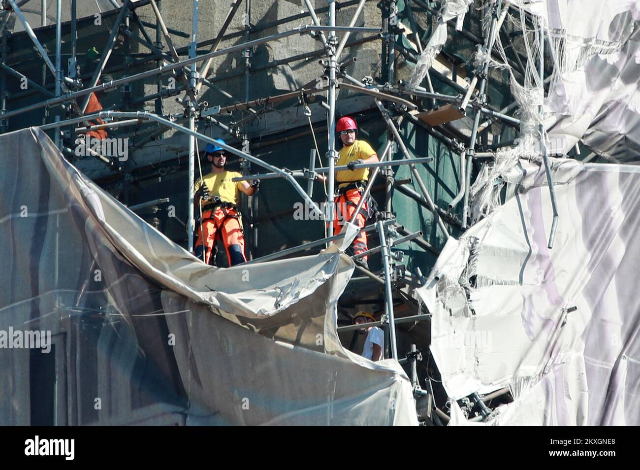 Workers repair a broken scaffolding that was destroyed by the fall of ...