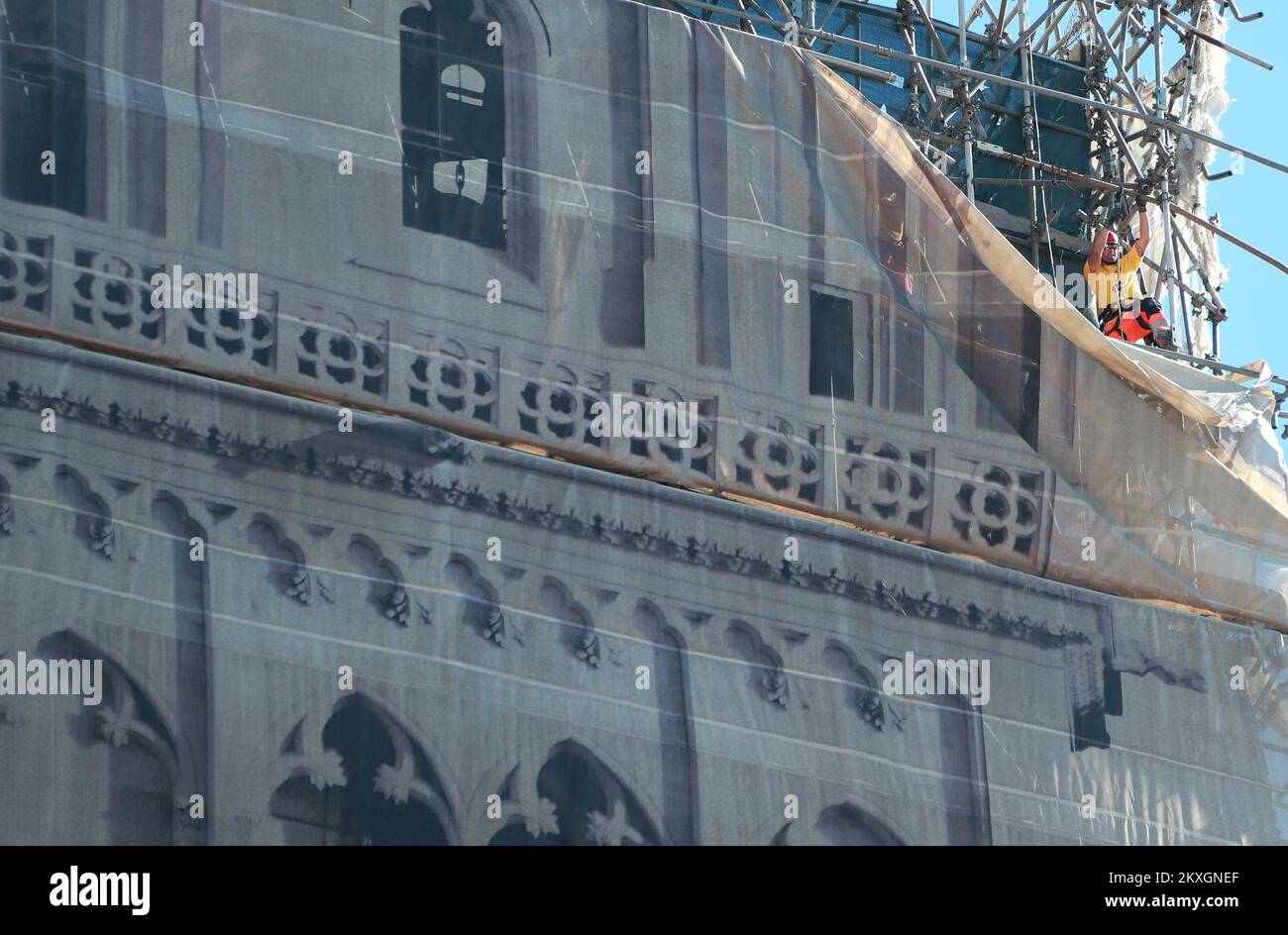 Workers repair a broken scaffolding that was destroyed by the fall of ...