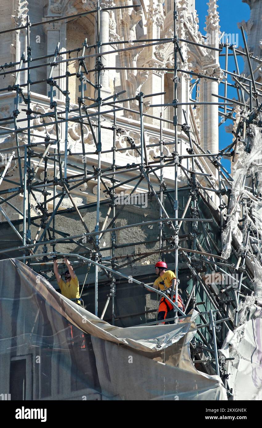 Workers repair a broken scaffolding that was destroyed by the fall of ...