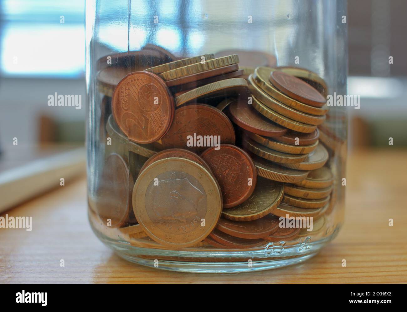 glass jar of savings filled with euro coins for expending in coffee ...