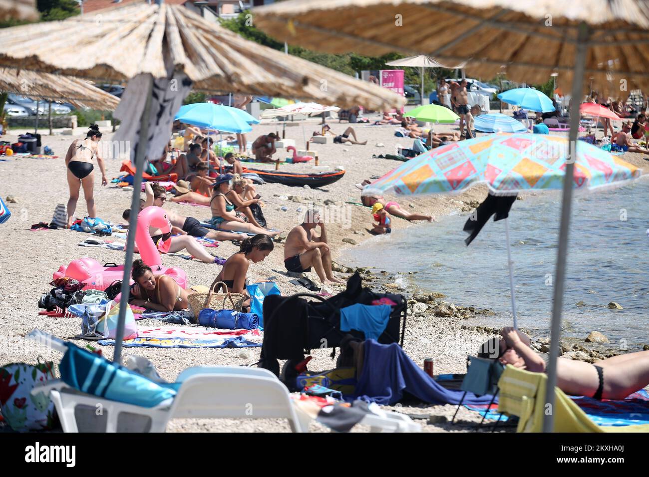 Tourists enjoy the sea and the sun on the Rezaliste beach in Sibenik ...