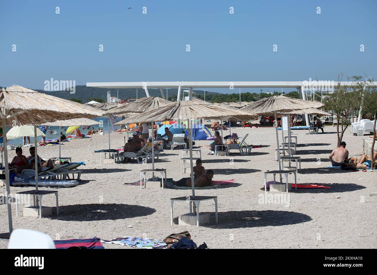 Tourists enjoy the sea and the sun on the Rezaliste beach in Sibenik ...