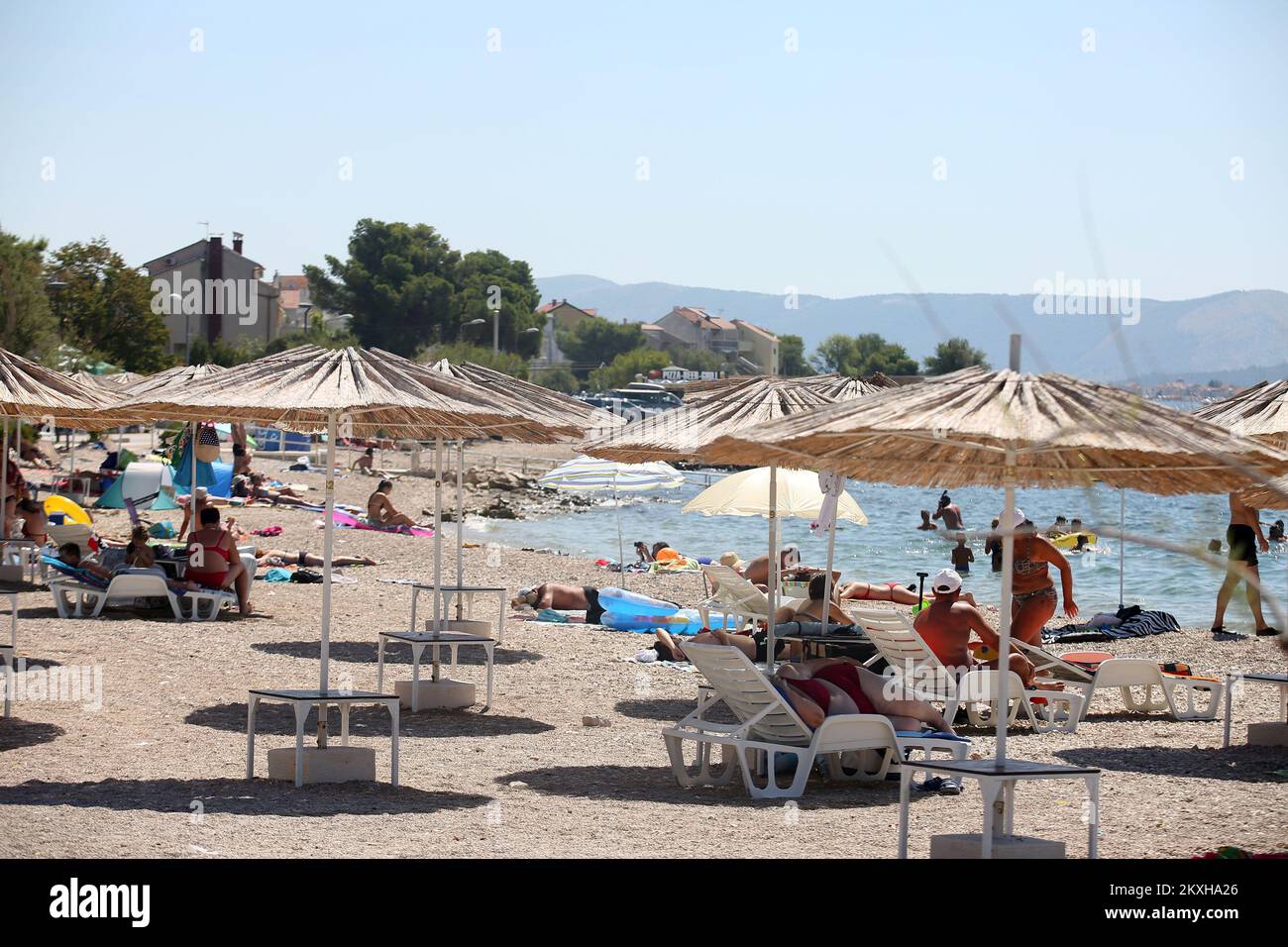 Tourists enjoy the sea and the sun on the Rezaliste beach in Sibenik ...