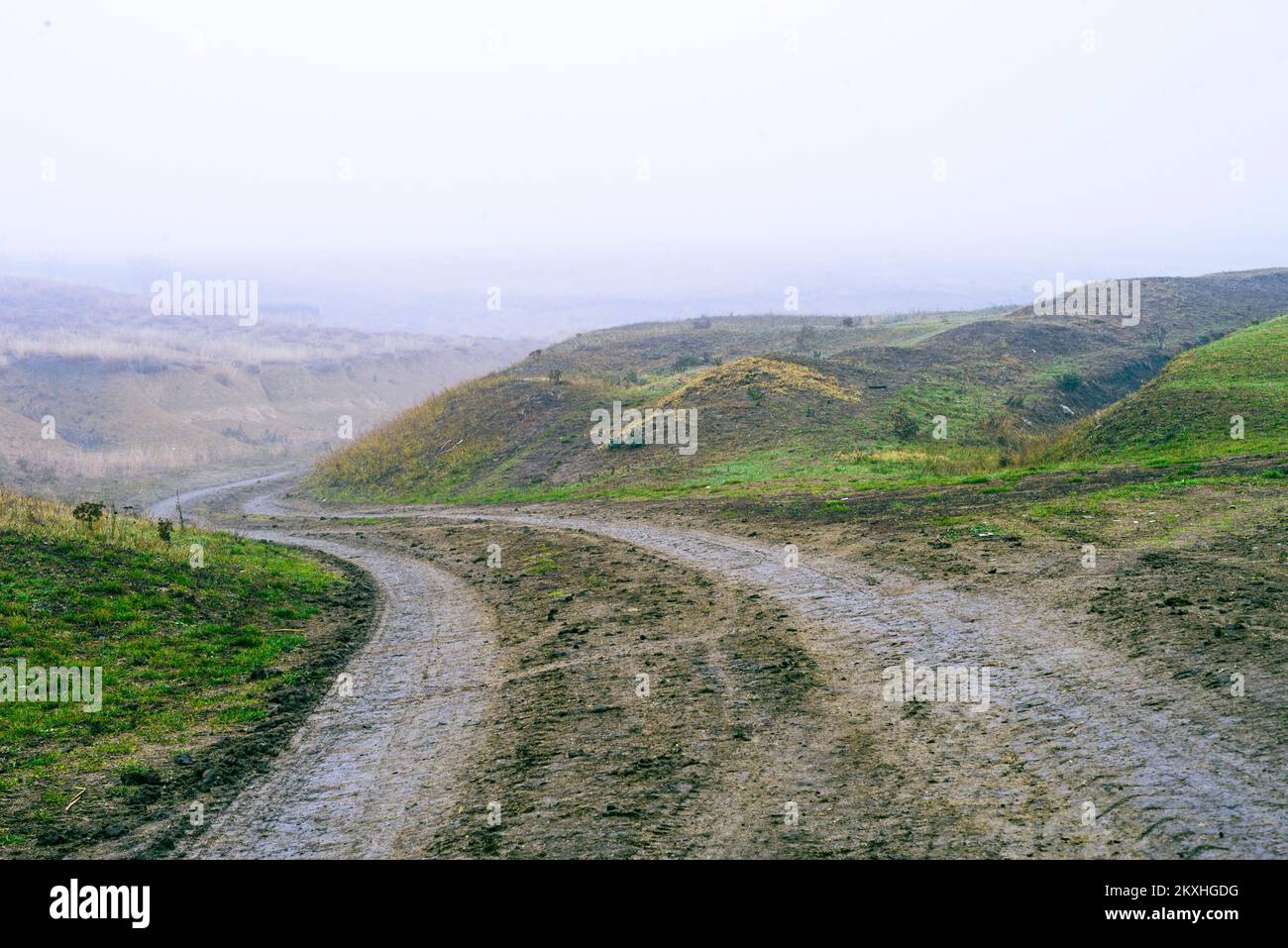dirt muddy road wet Puddle countryside autumn fall green grass steppe ...