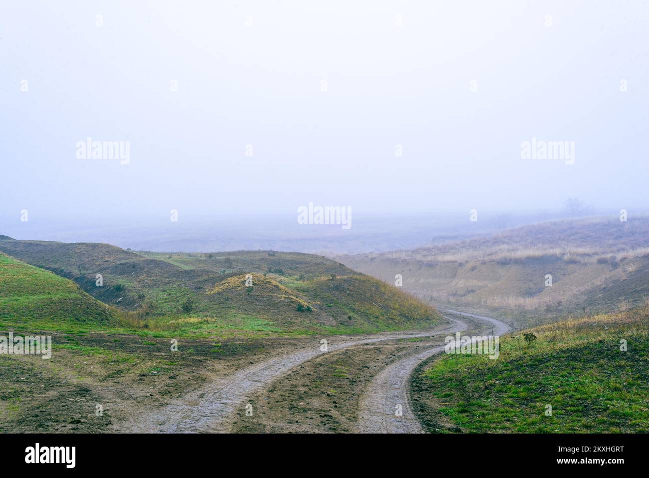 dirt muddy road wet Puddle countryside autumn fall green grass steppe ...