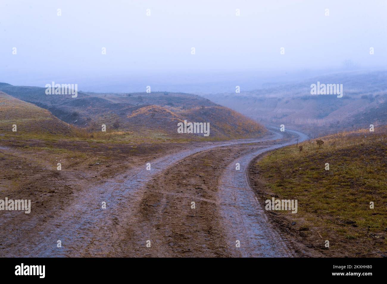 dirt muddy road wet Puddle countryside autumn fall green grass steppe ...