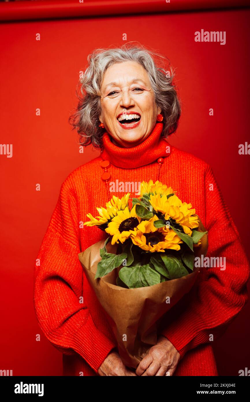 Senior woman wearing red clothes, over a red background Stock Photo - Alamy