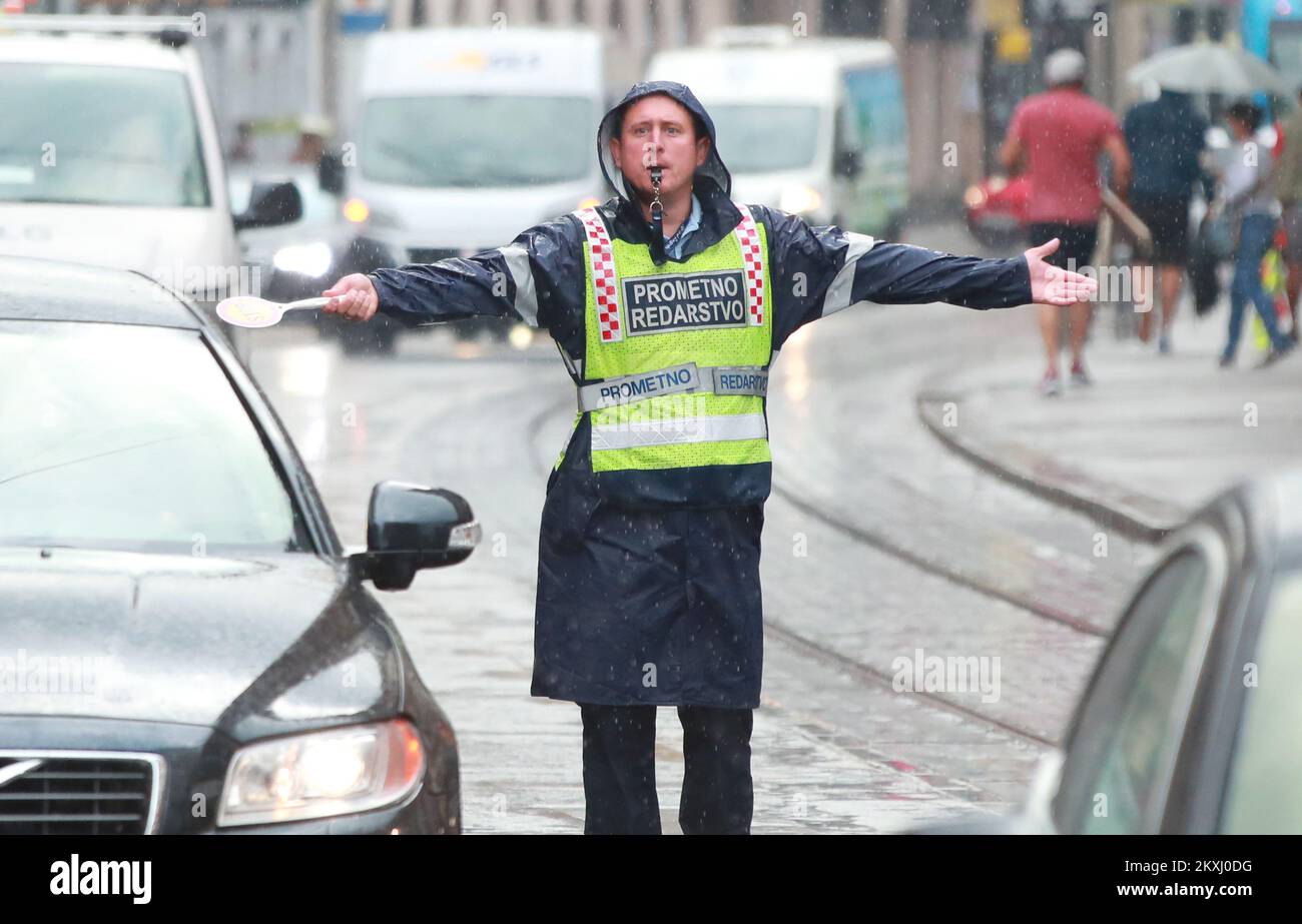 A traffic police officer in the rain controls traffic on Ilica Street ...