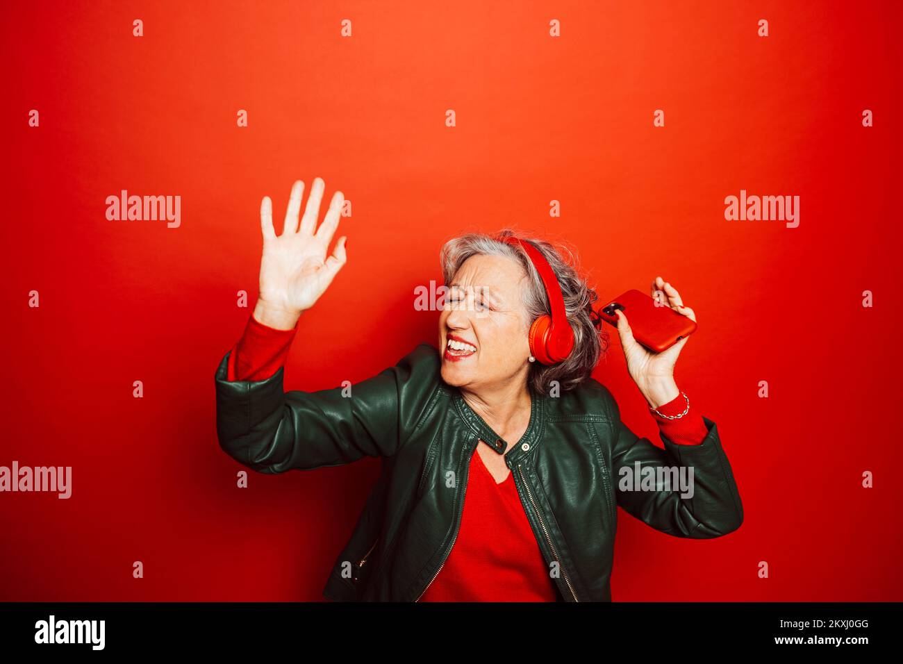 Senior woman wearing red clothes, over a red background Stock Photo - Alamy
