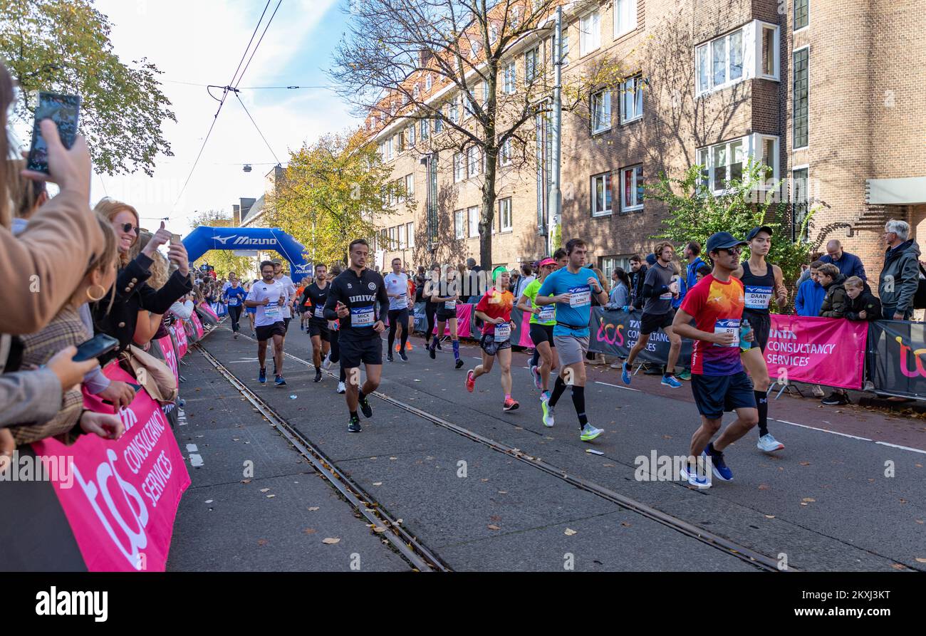 A picture of multiple runners near the start of the Amsterdam Marathon ...