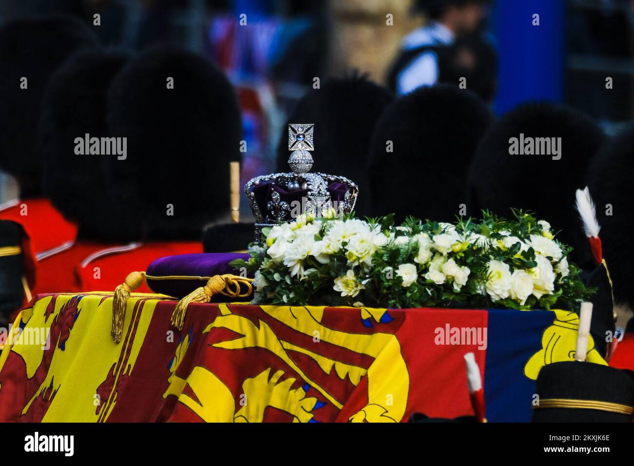 The coffin is adorned with the Royal Standard , Imperial State Crown ...
