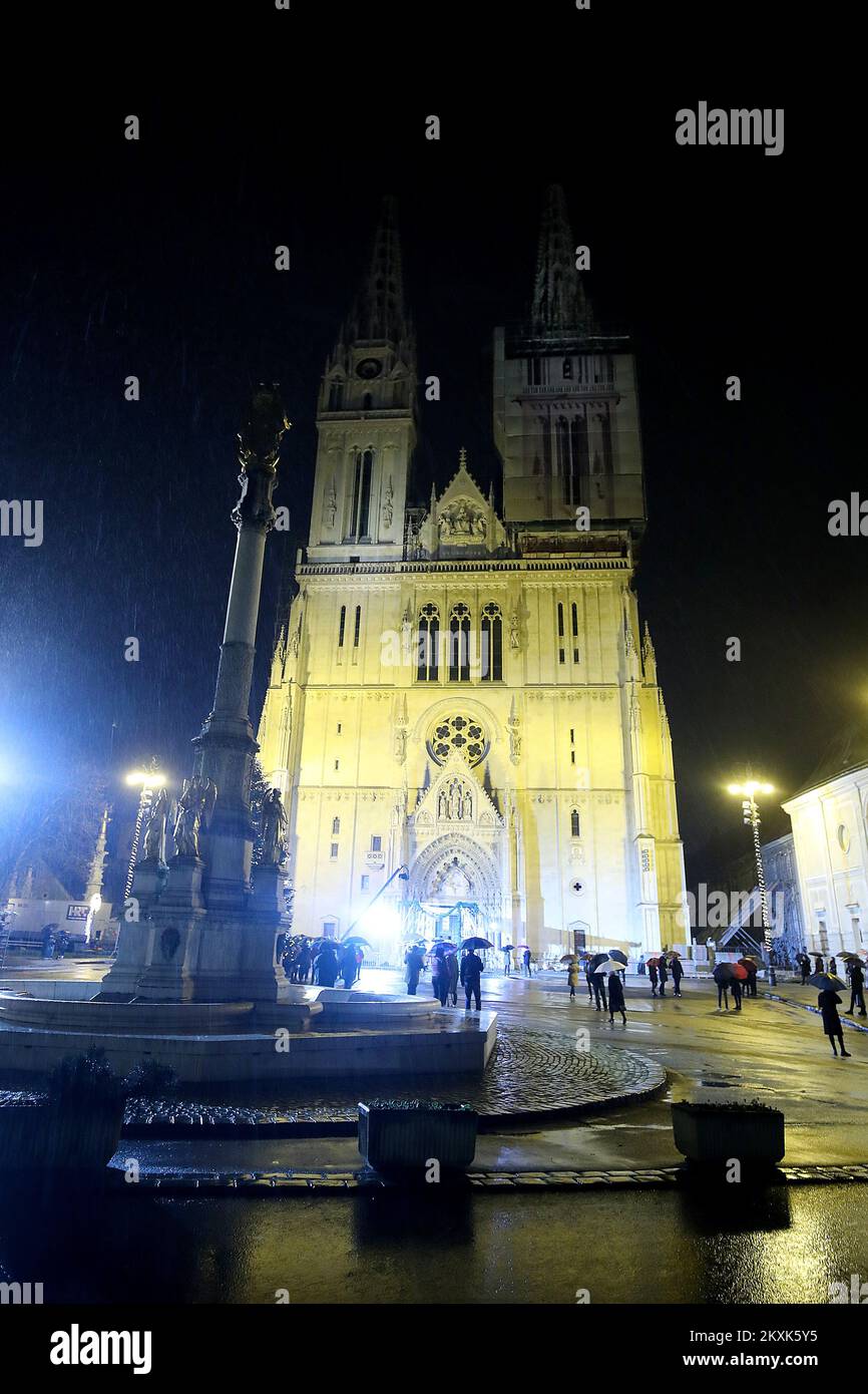 Believers seen attending midnight mass in the rain in front of the ...