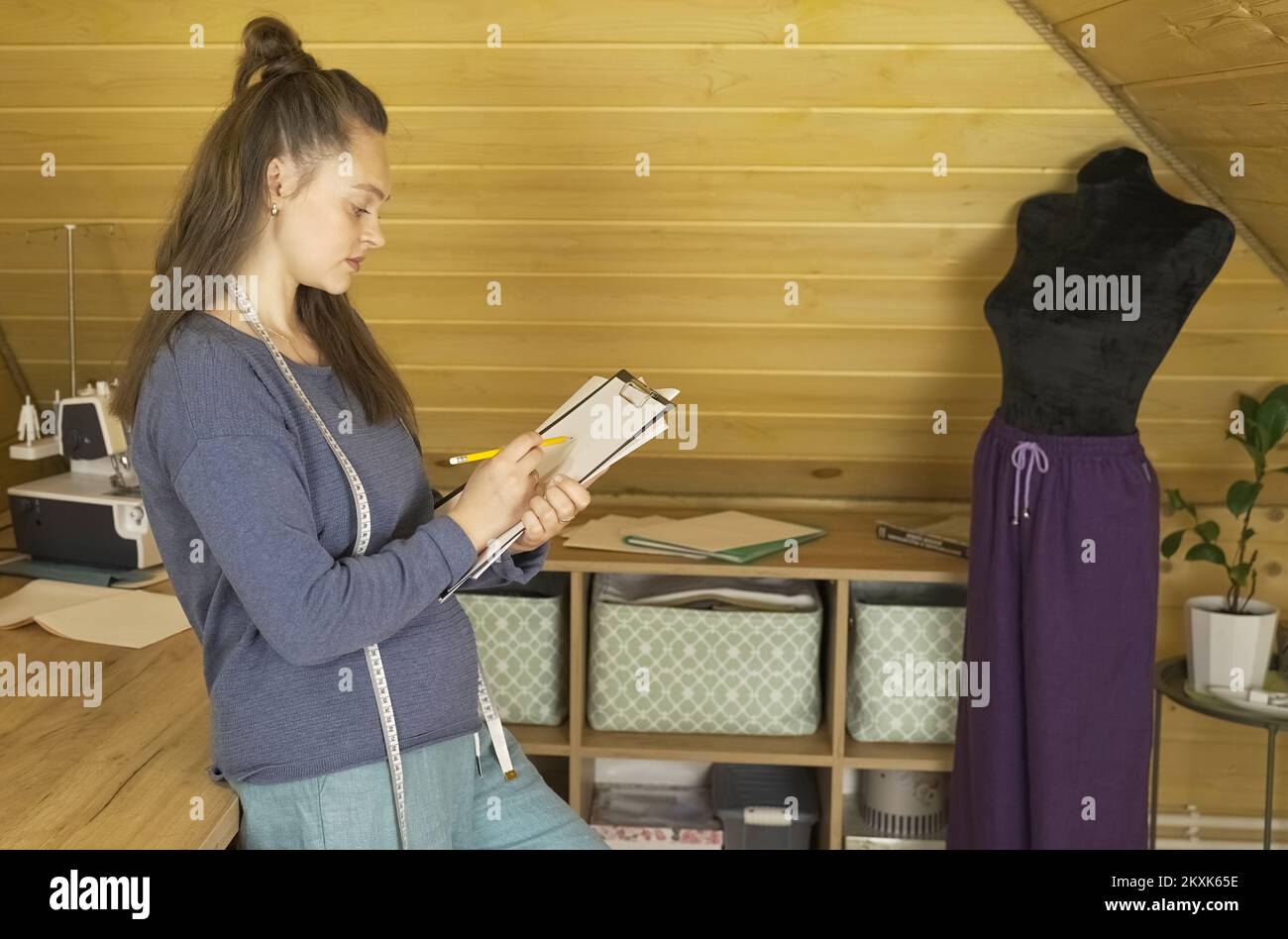 Fashion business. Fashion designer draws a sketch of future clothes ...