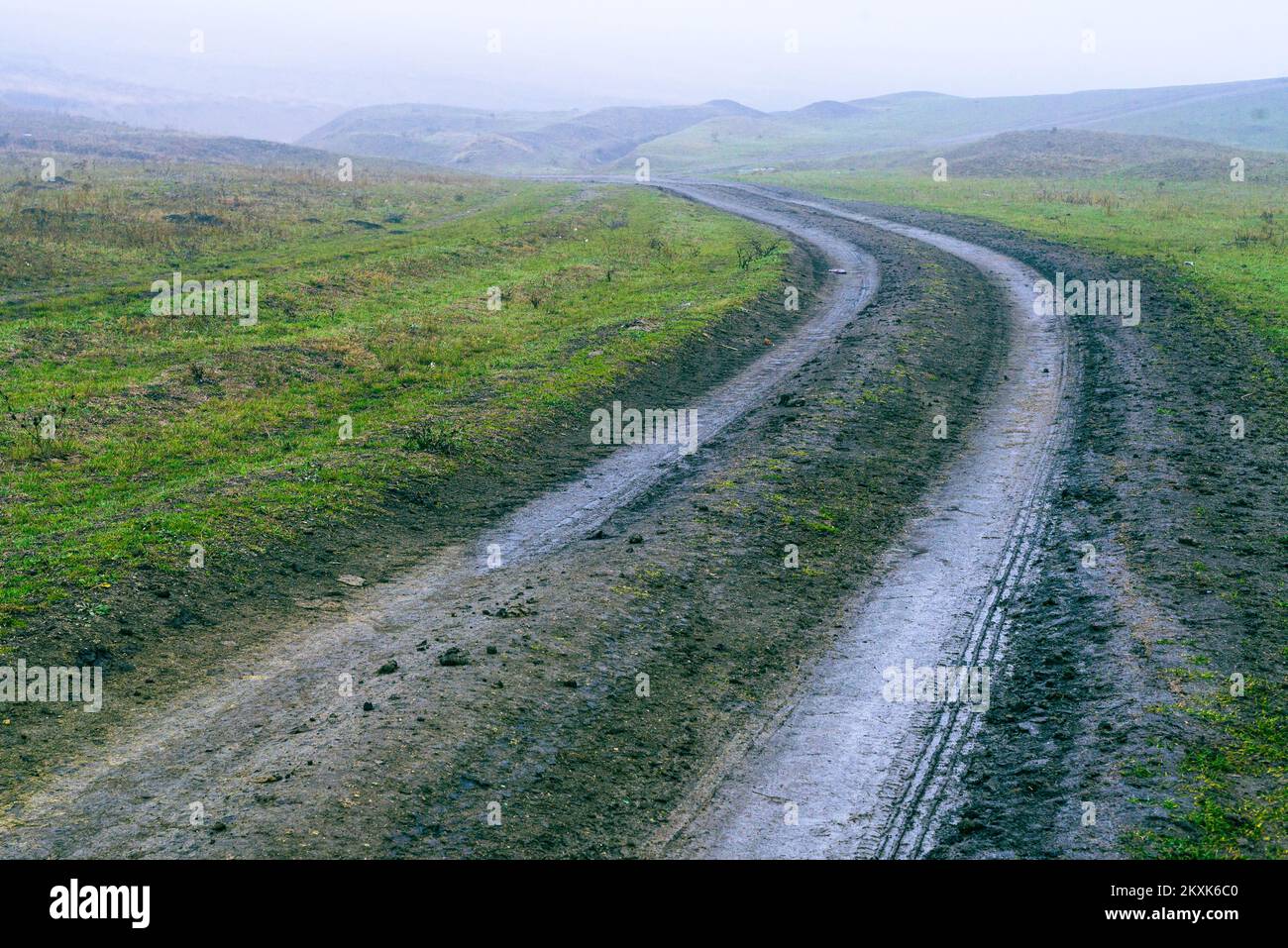 dirt muddy road wet Puddle countryside autumn fall green grass steppe ...