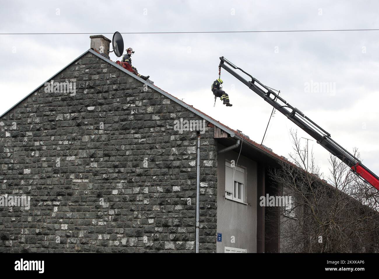Firefighters repairing the damage on the roof which was damaged in ...