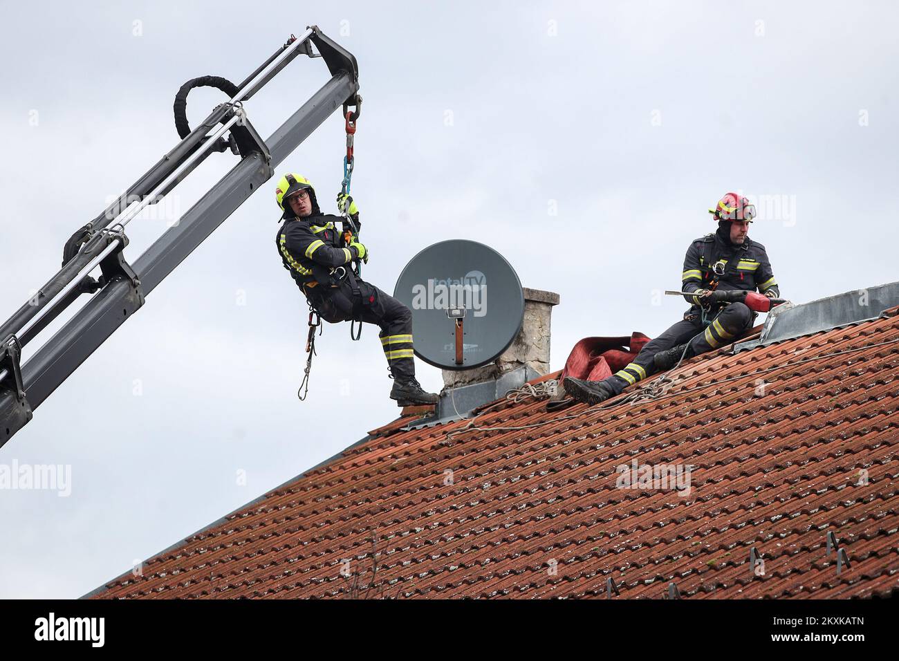 Firefighters repairing the damage on the roof which was damaged in ...