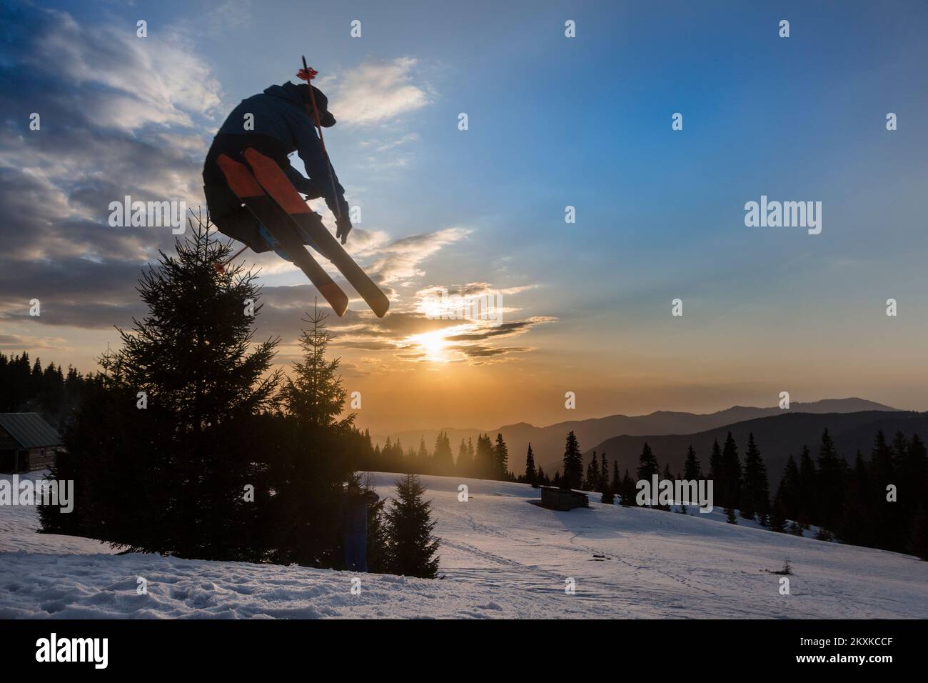 Freestyle extreme skier jumping from kicker in snowy mountains at ...