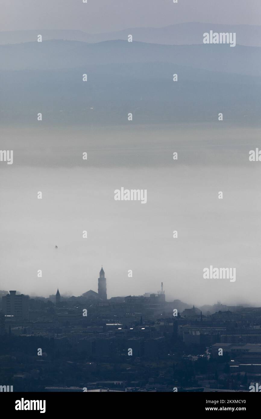View from the Kozjak hill on the fog-covered parts of the city of Split ...