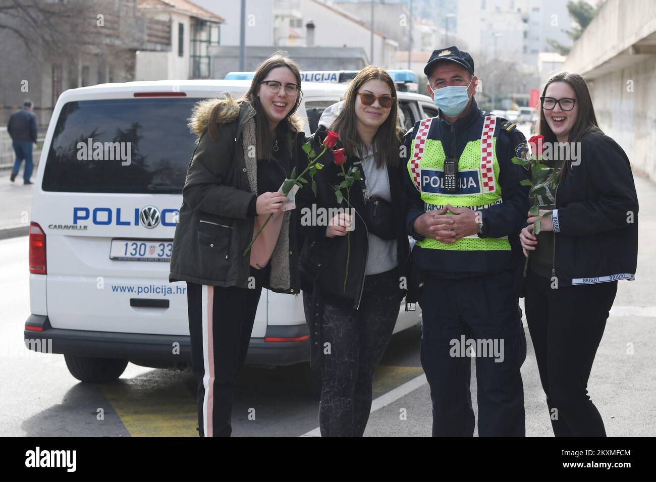 Police officer posing with the women after giving them roses ,in ...