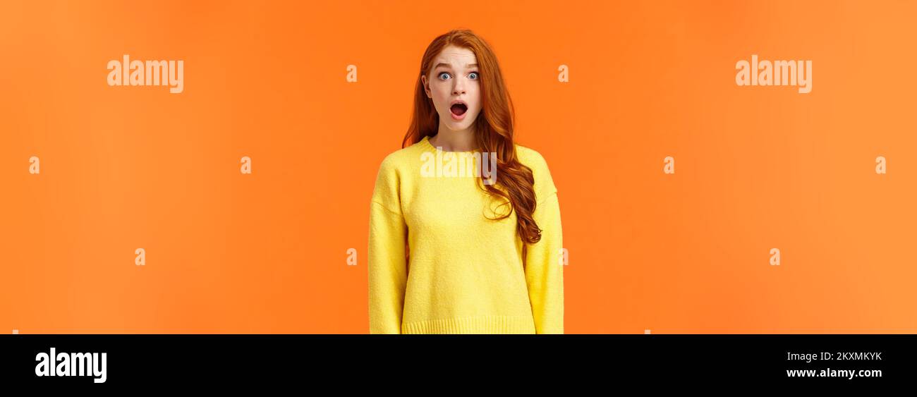 Shocked redhead cute girl drop jaw astounded and speechless, stare ...