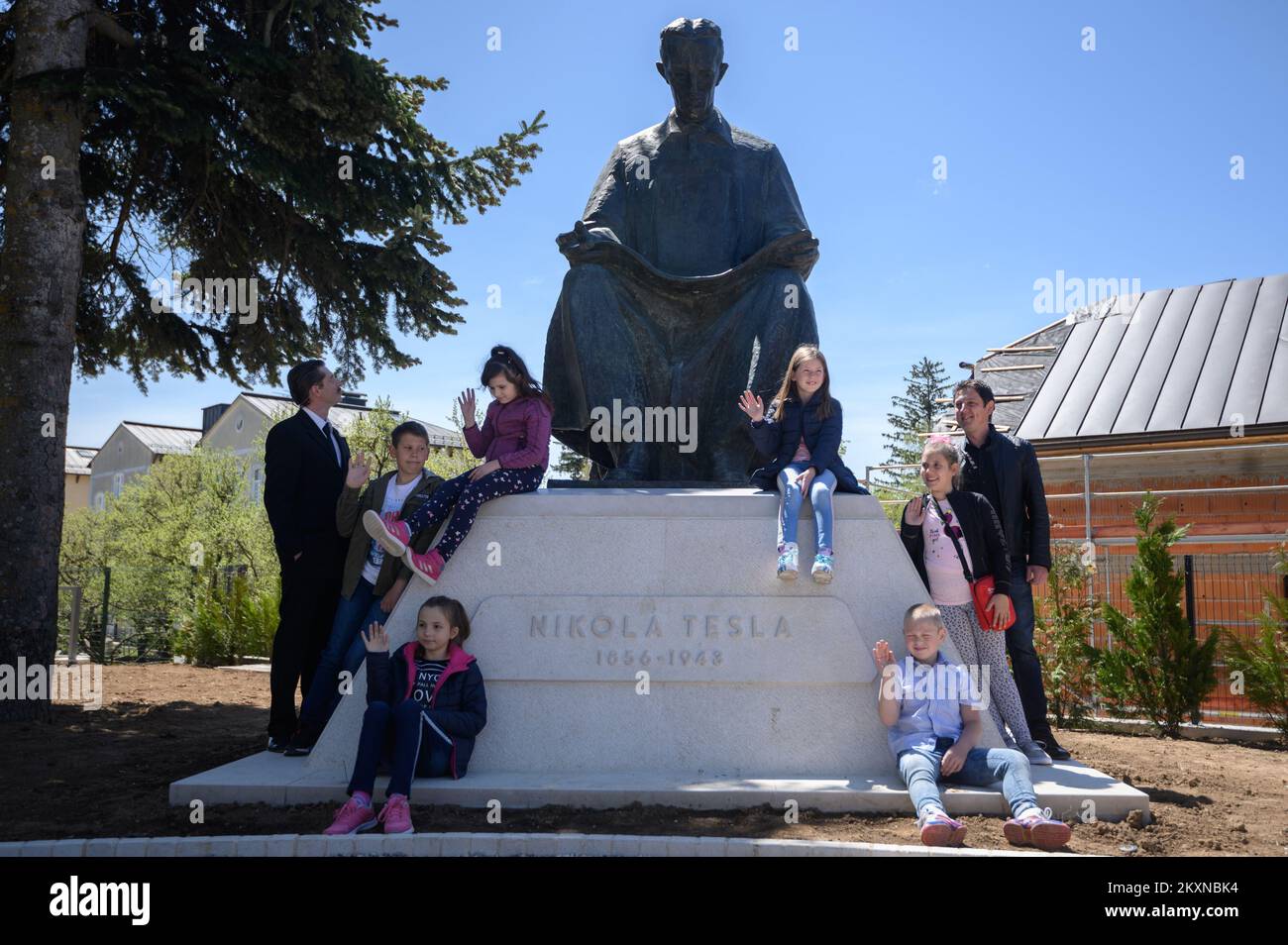 Children pose next to a replica of a monument replica of a statue of ...