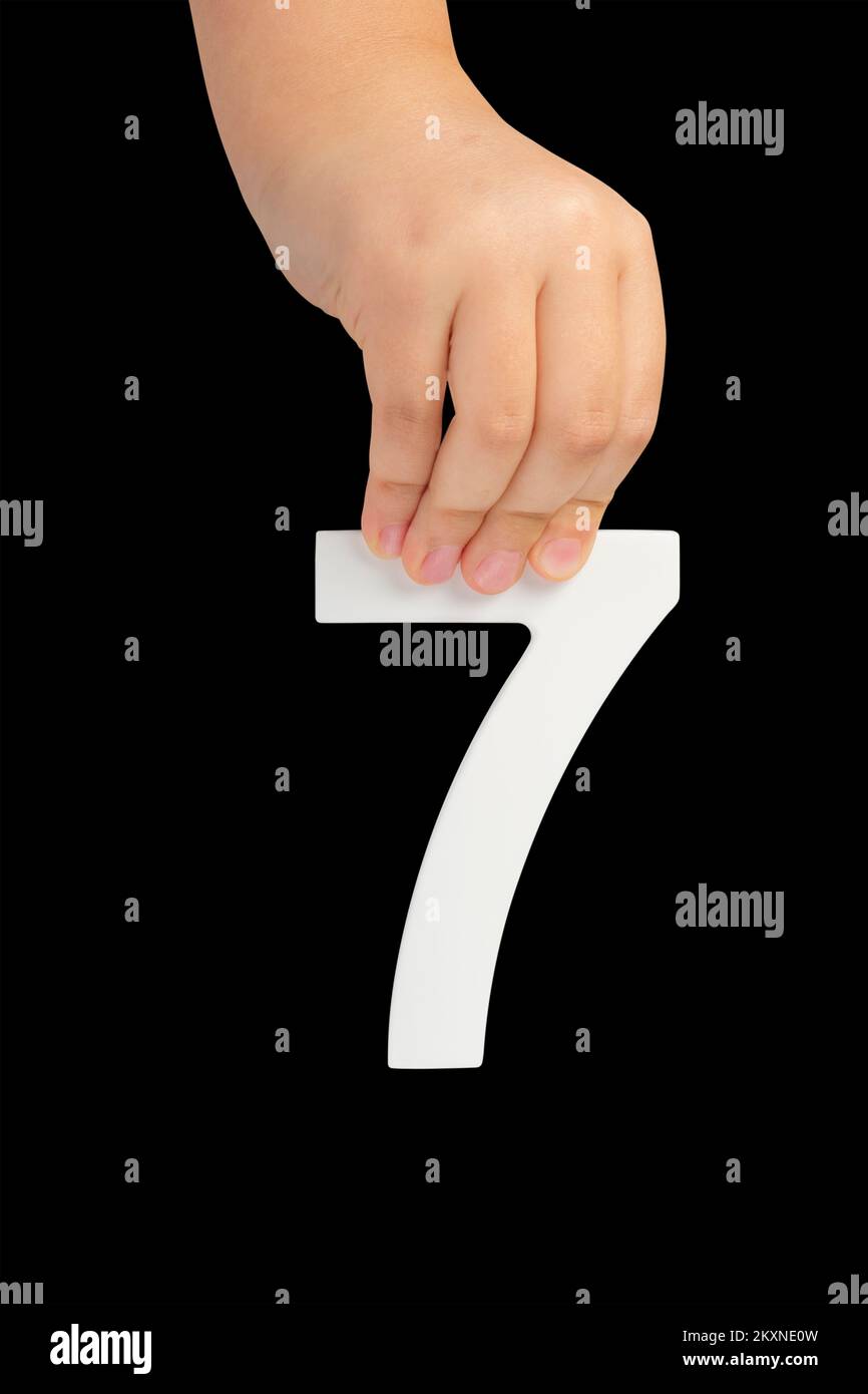 Number seven in hand isolated on black background. Number 7 in a child ...