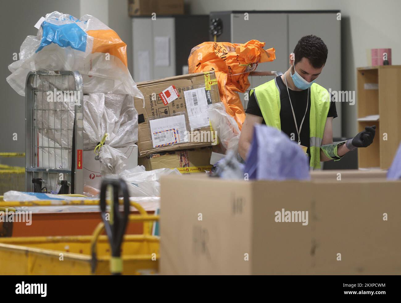 Postal workers are seen sorting packages at the Central Sorting Center ...