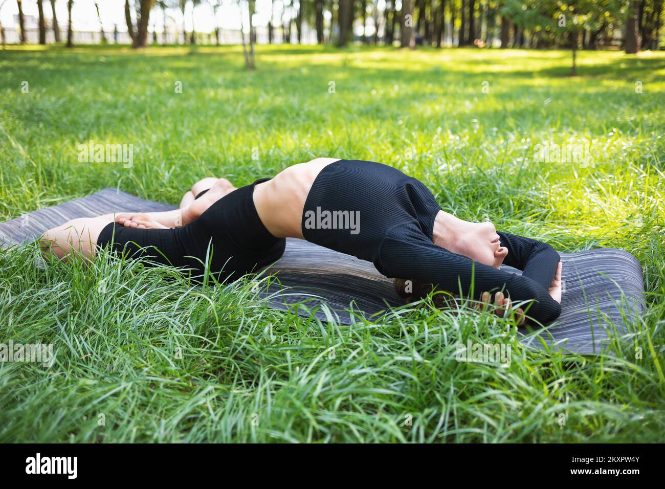 Young woman leading a healthy lifestyle and practicing yoga, doing ...