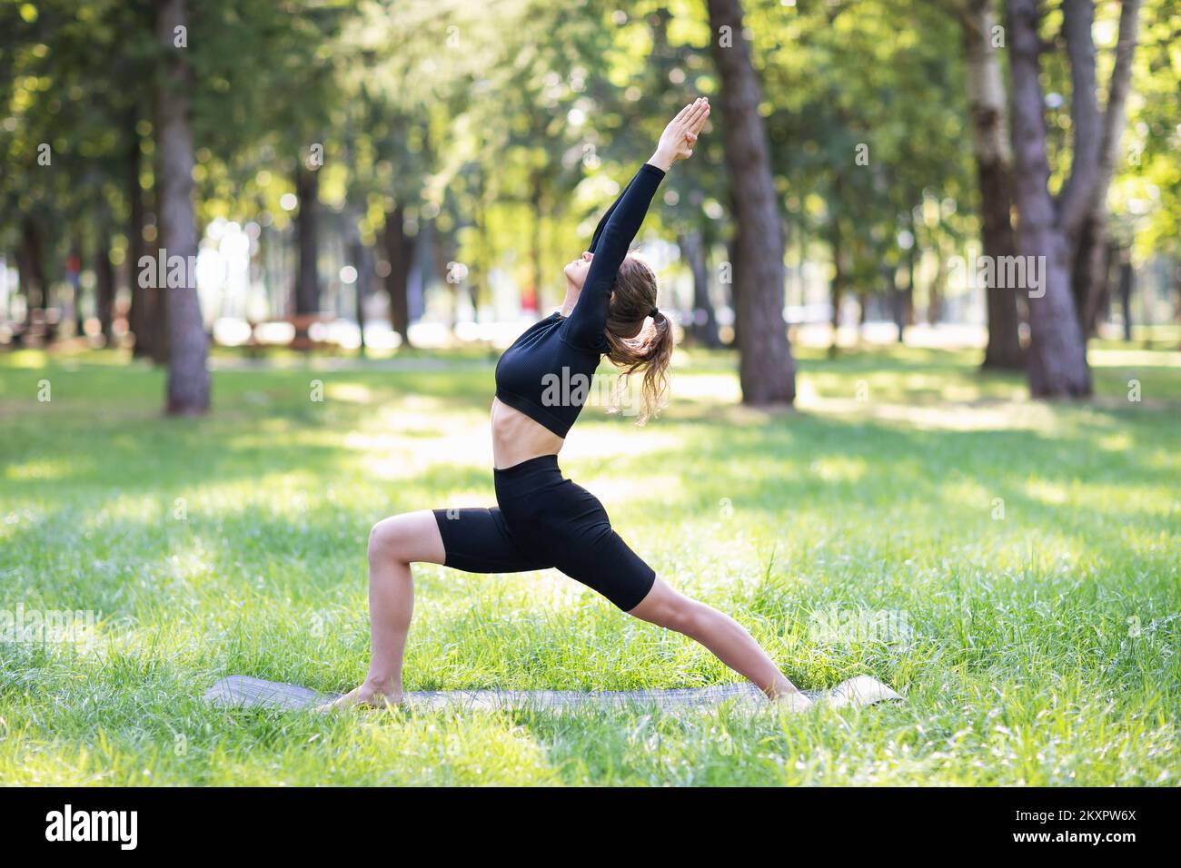 Young woman leading a healthy lifestyle and practicing yoga, performs ...