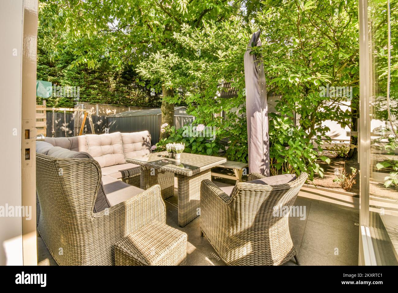 Neat powerful patio with sitting area and small garden near wooden ...