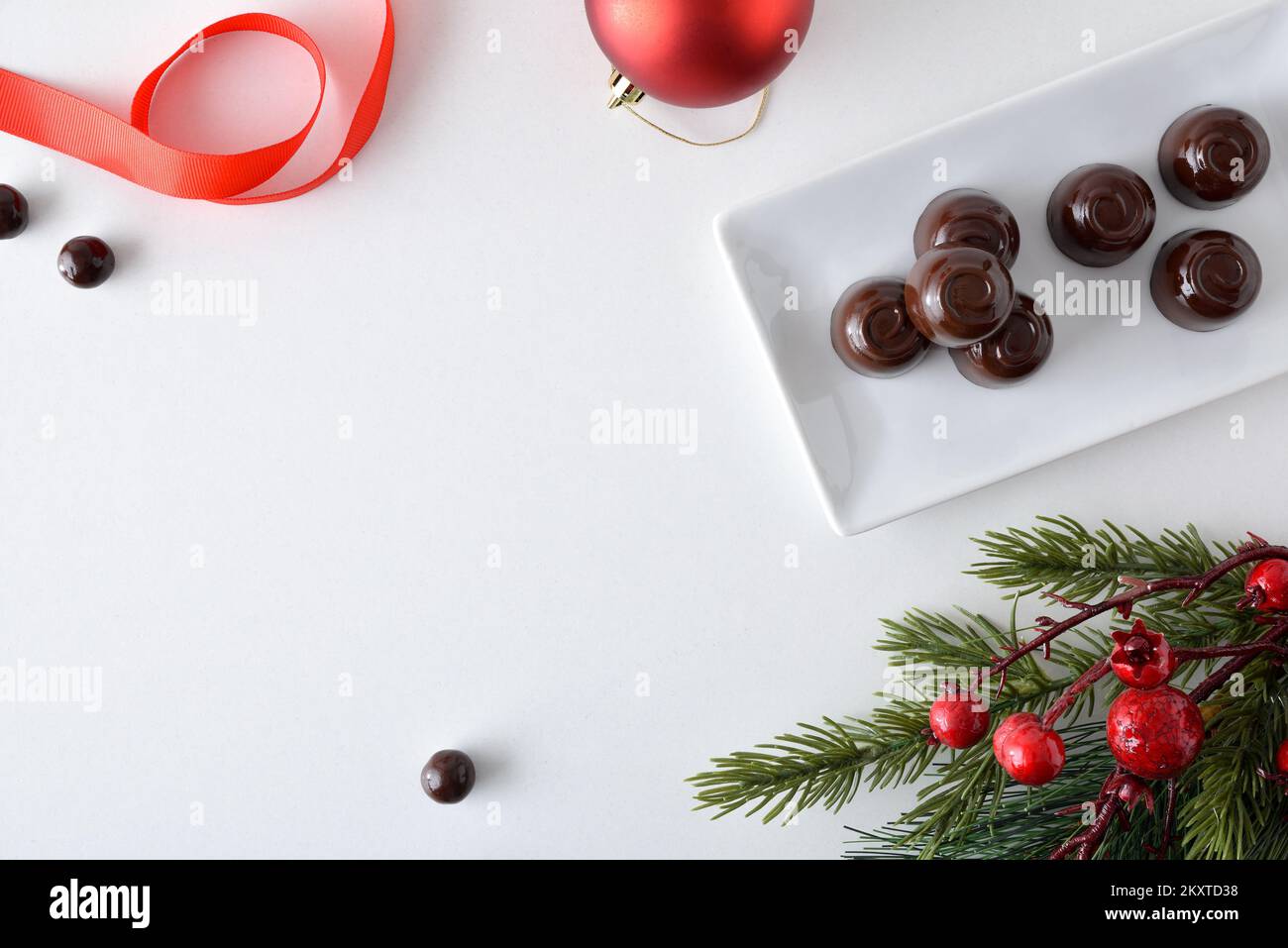 Chocolate candies on a rectangular plate on a white table with ...